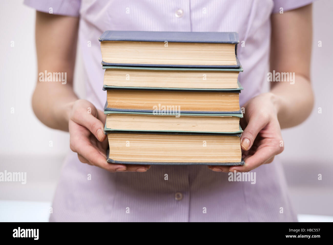 Young student with stack of books Stock Photo - Alamy