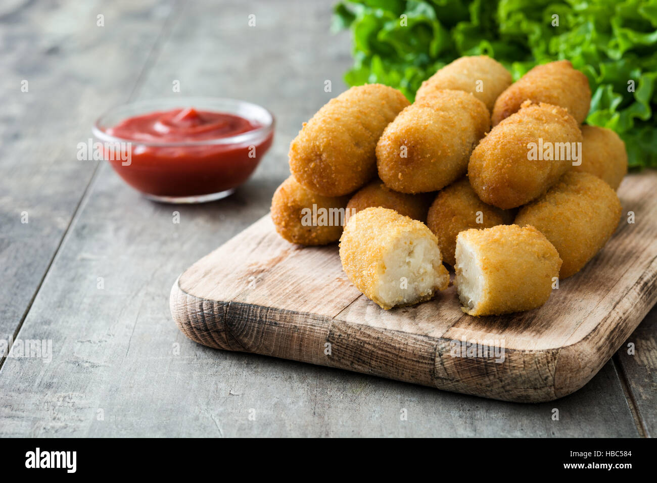 Traditional fried Spanish croquetas (croquettes) with ketchup on wooden ...