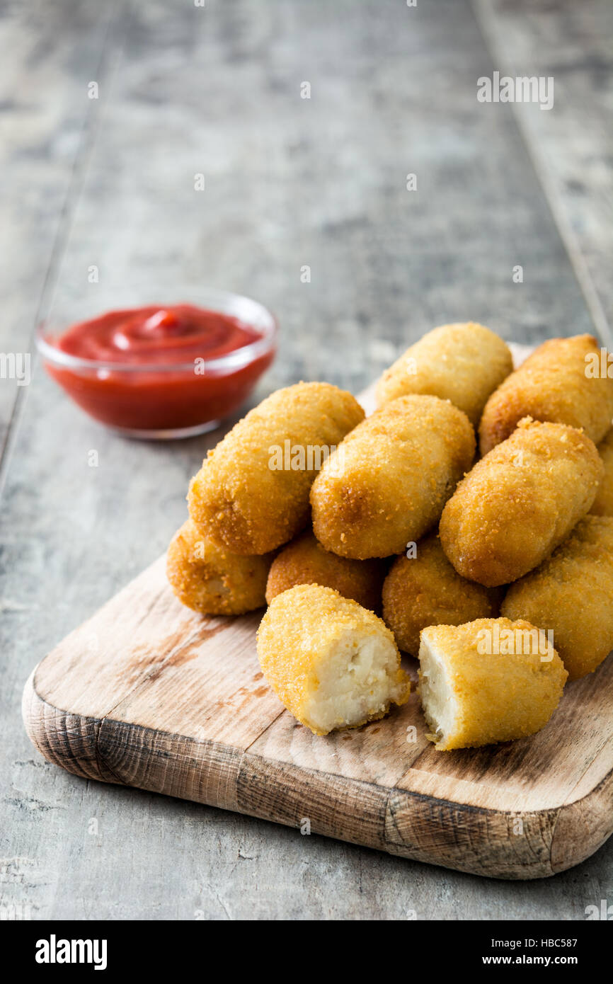 Traditional fried Spanish croquetas (croquettes) with ketchup on wooden ...