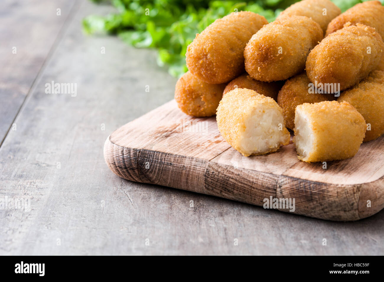 Traditional fried Spanish croquetas (croquettes) with ketchup on wooden ...