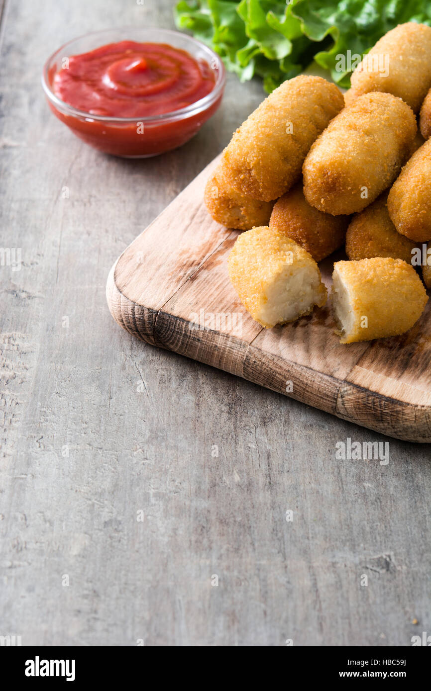 Traditional fried Spanish croquetas (croquettes) with ketchup on wooden ...