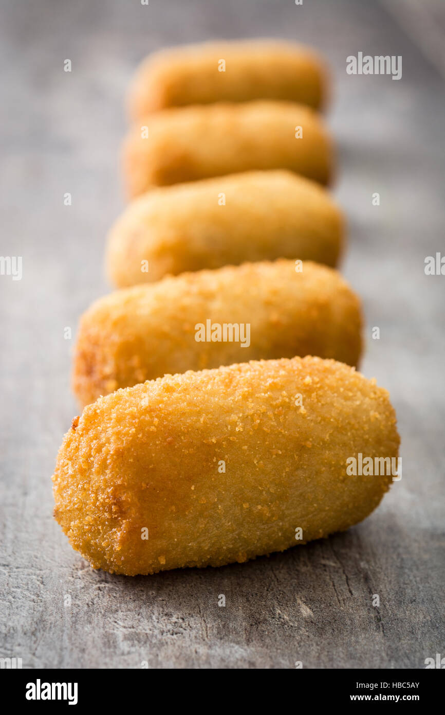 Traditional fried Spanish croquetas (croquettes) on wooden background ...