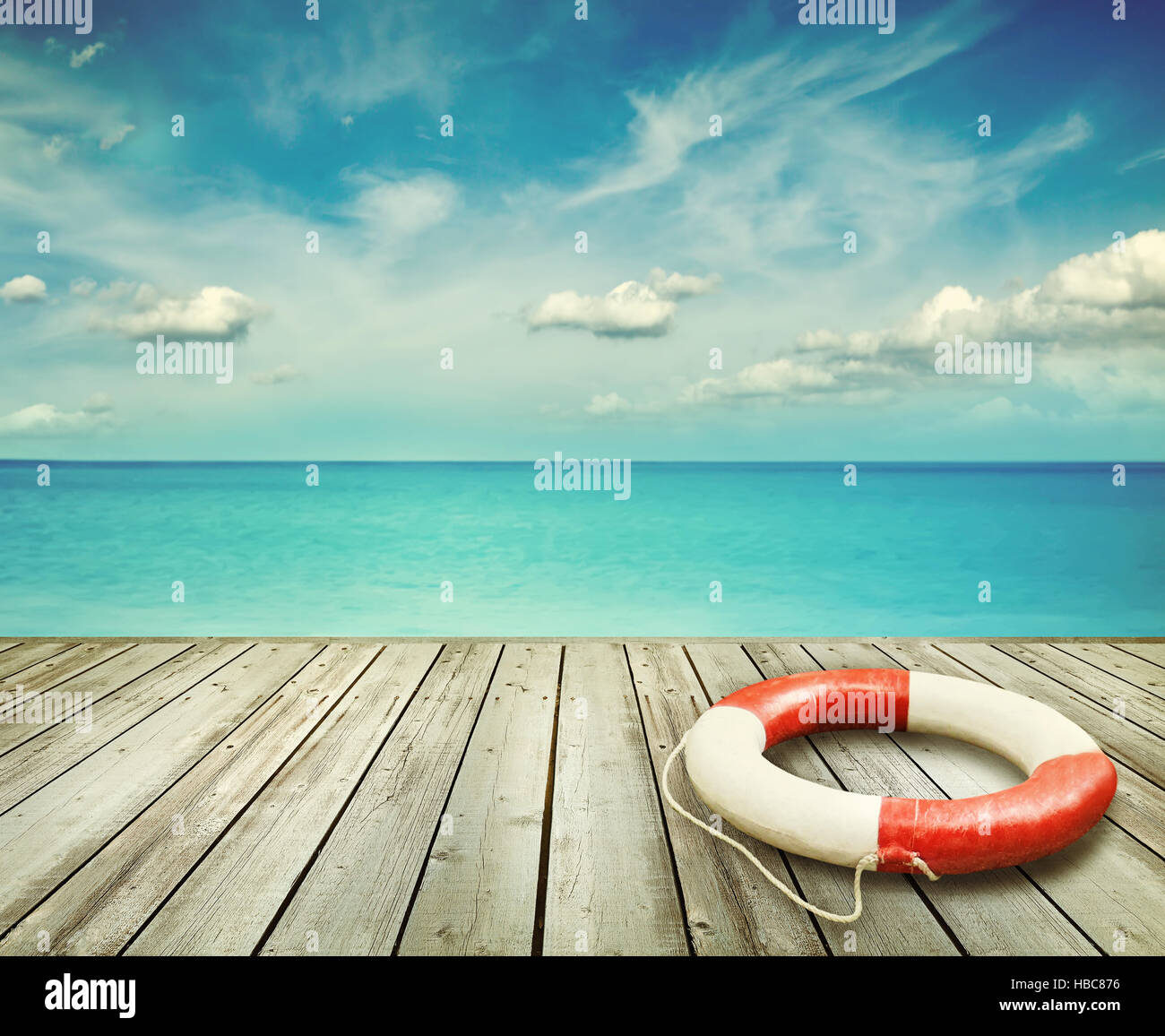 Wood pier with ocean and life preserver Stock Photo - Alamy
