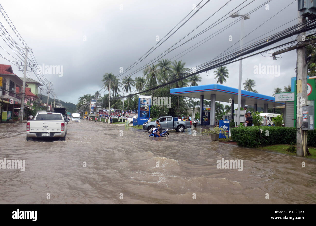 Koh Samui, Thailand. 6th Dec, 2016. Vehicles driving along a flooded ...