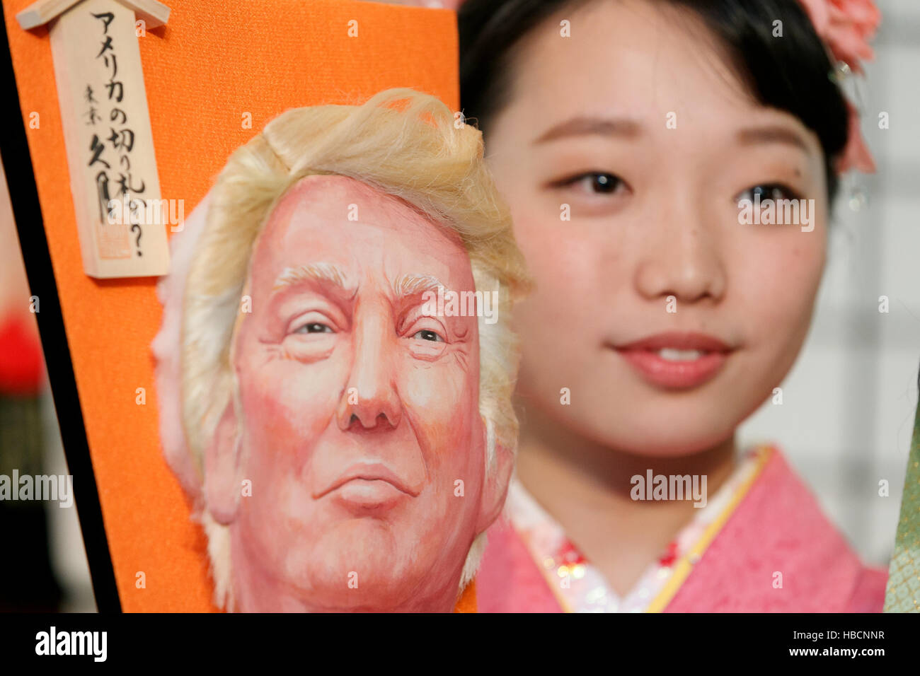 A staff member wearing traditional kimono holds a Hagoita Paddle ...