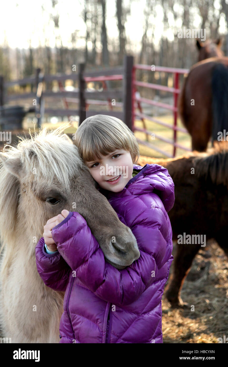 Portrait of young girl outdoors, hugging pony Stock Photo - Alamy
