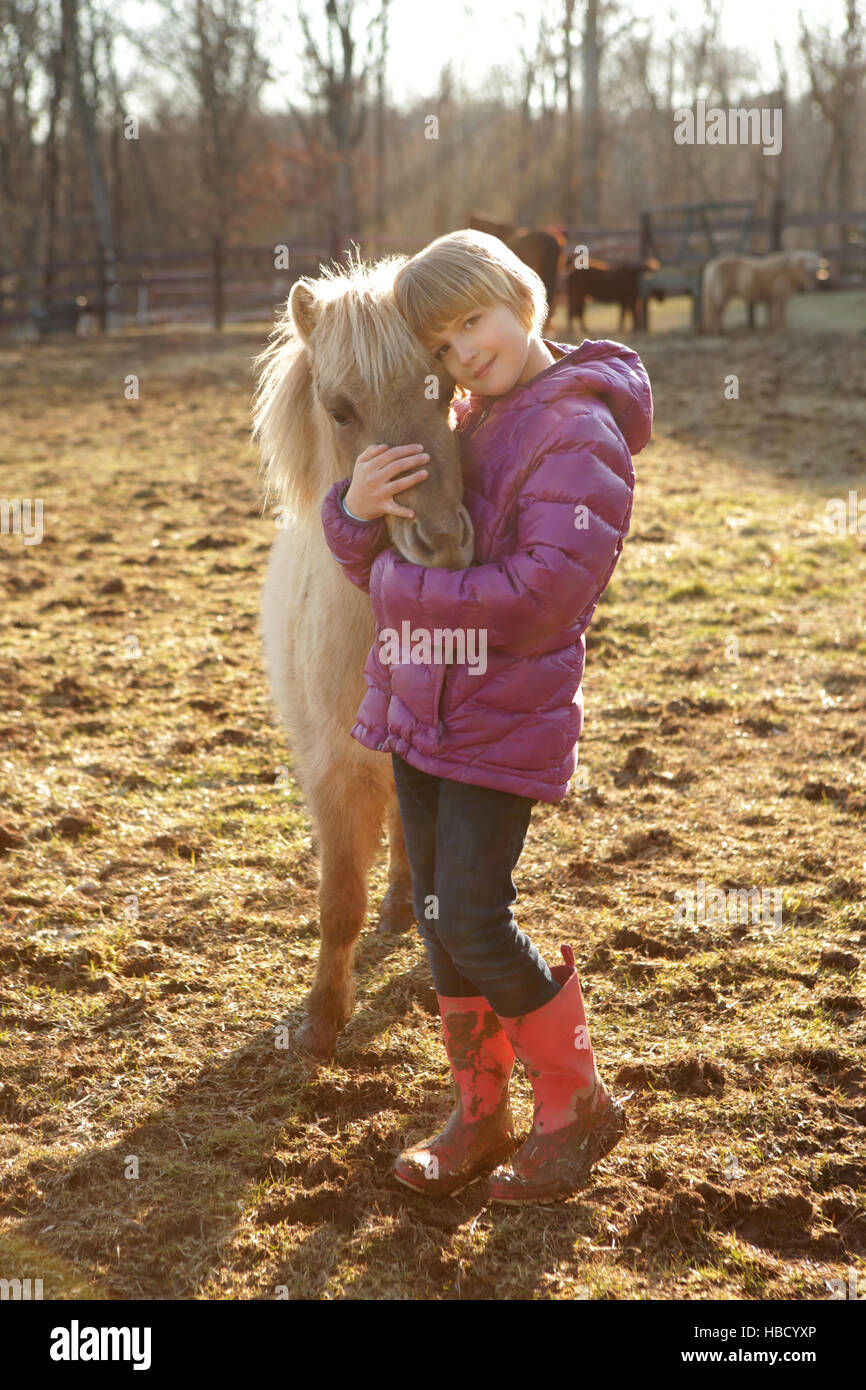 Portrait of young girl outdoors, hugging pony Stock Photo - Alamy