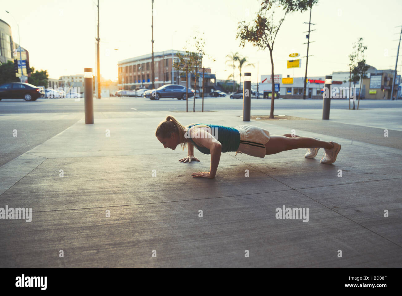 Young woman doing push-ups in street Stock Photo - Alamy