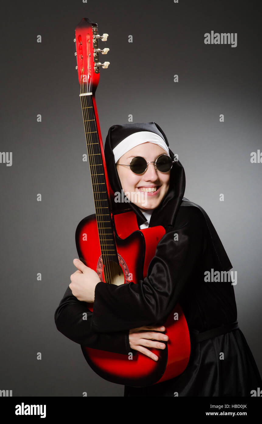 Funny nun with red guitar playing Stock Photo - Alamy