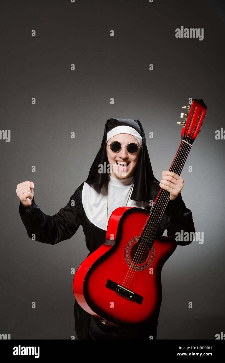 Funny nun with red guitar playing Stock Photo - Alamy