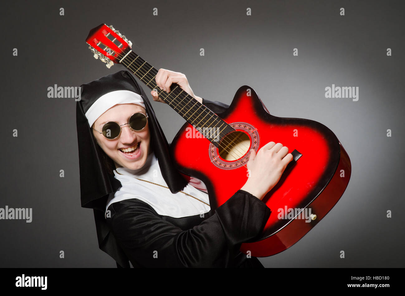 Funny nun with red guitar playing Stock Photo - Alamy
