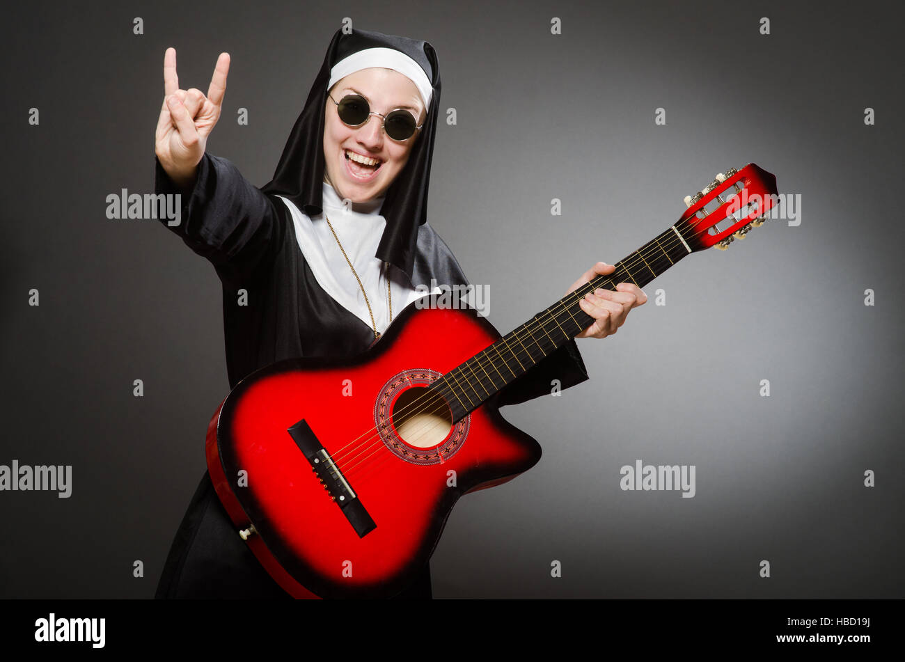 Funny nun with red guitar playing Stock Photo - Alamy