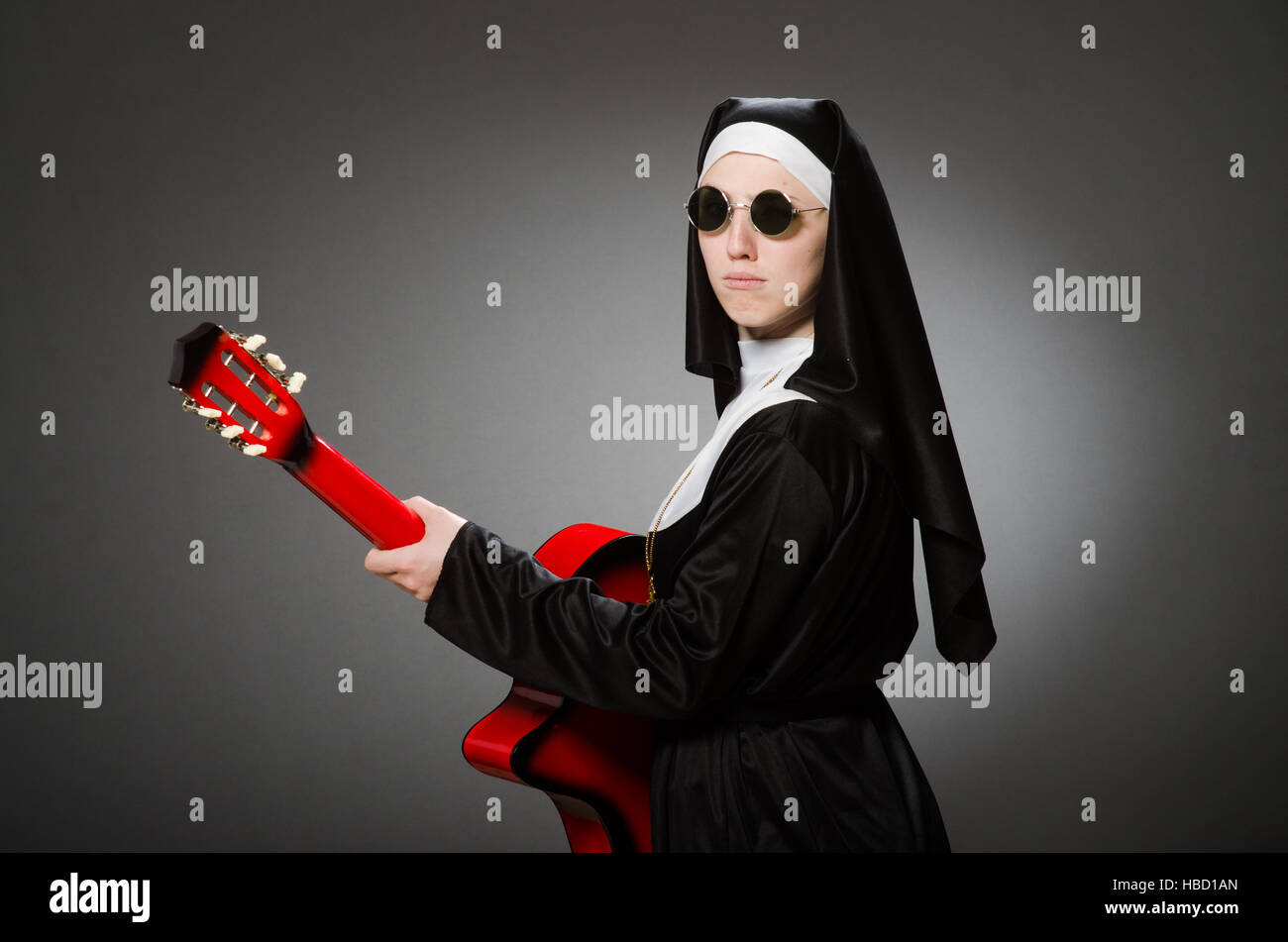 Funny nun with red guitar playing Stock Photo - Alamy
