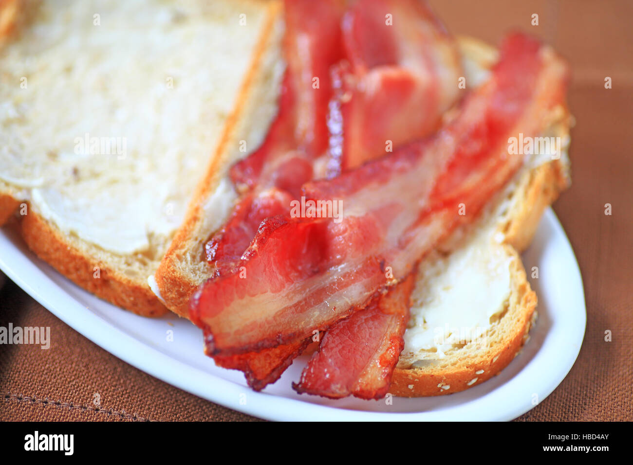 Thick bacon slices on buttered whole-grain bread Stock Photo - Alamy