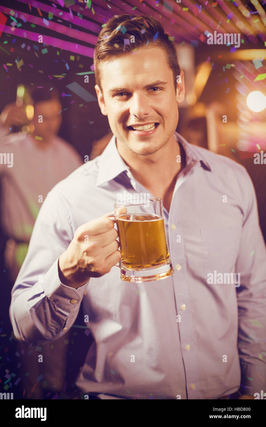 Composite image of smiling man holding glass of beer in bar Stock Photo ...