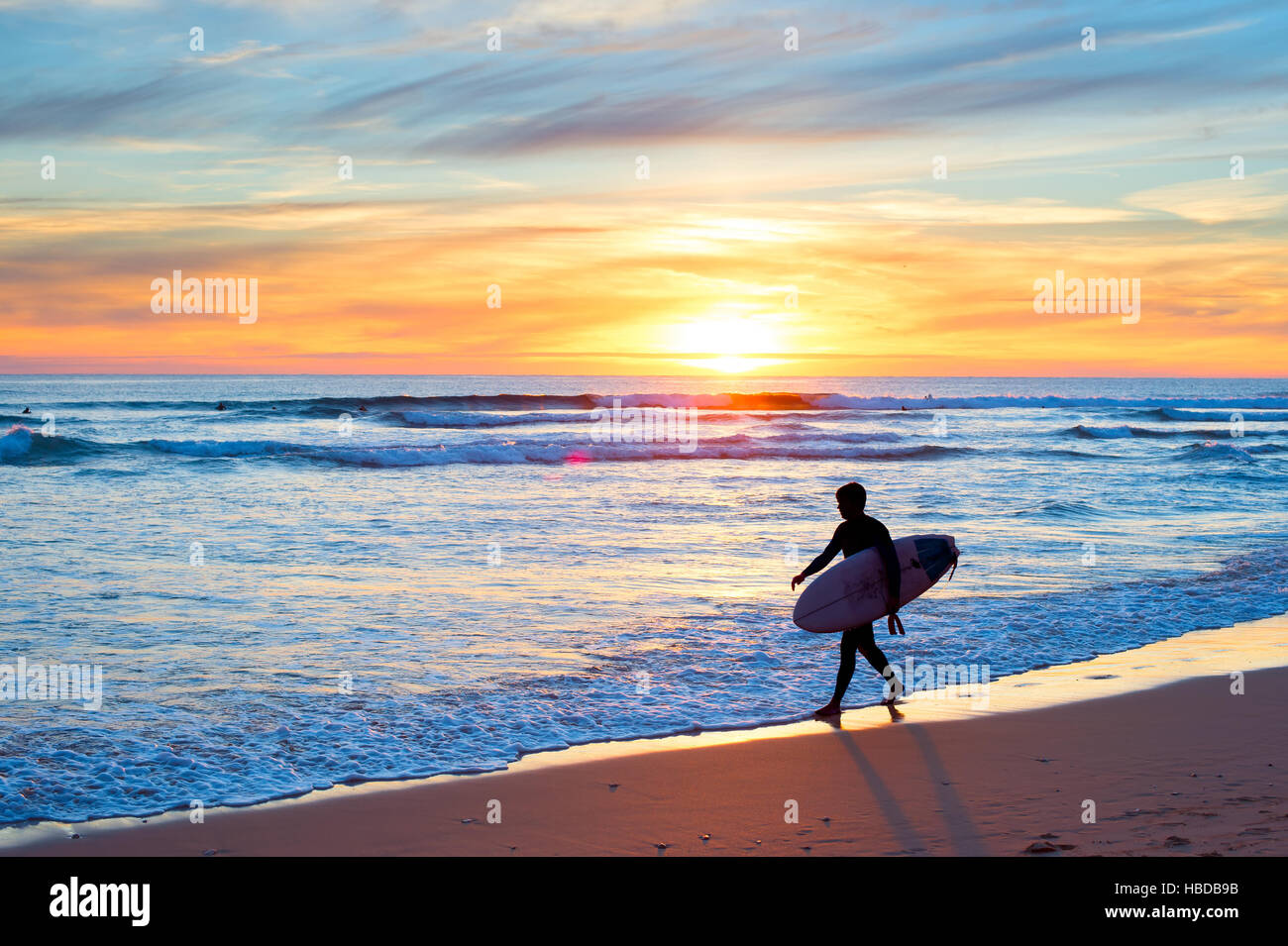 Surfing at sunset Stock Photo - Alamy