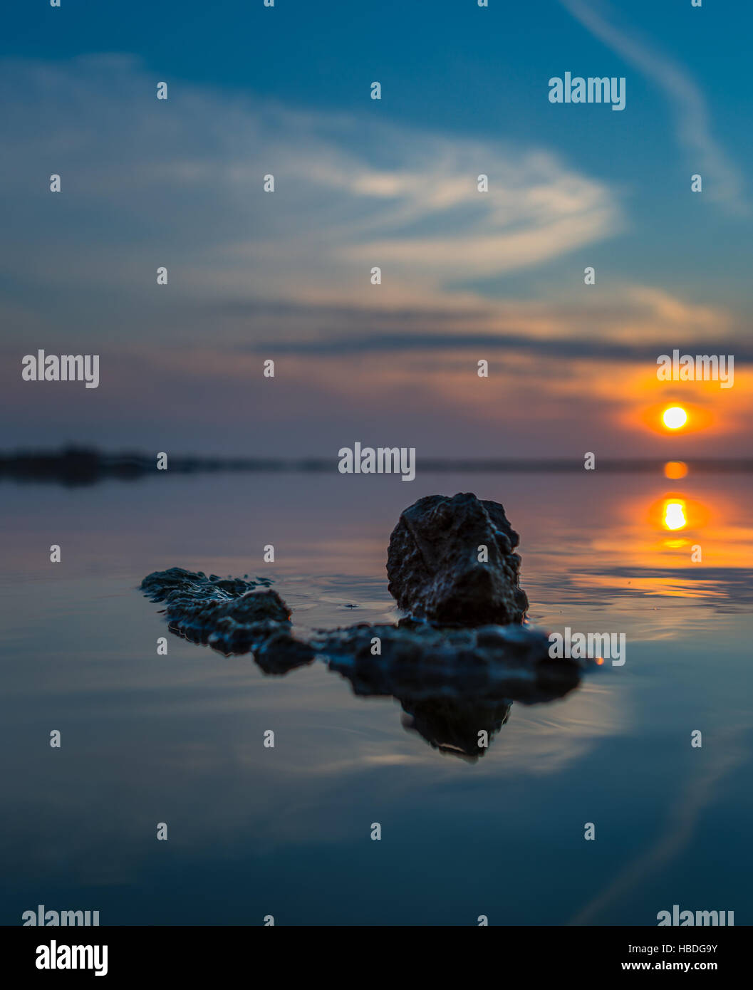 stone in the water at sunset Stock Photo - Alamy