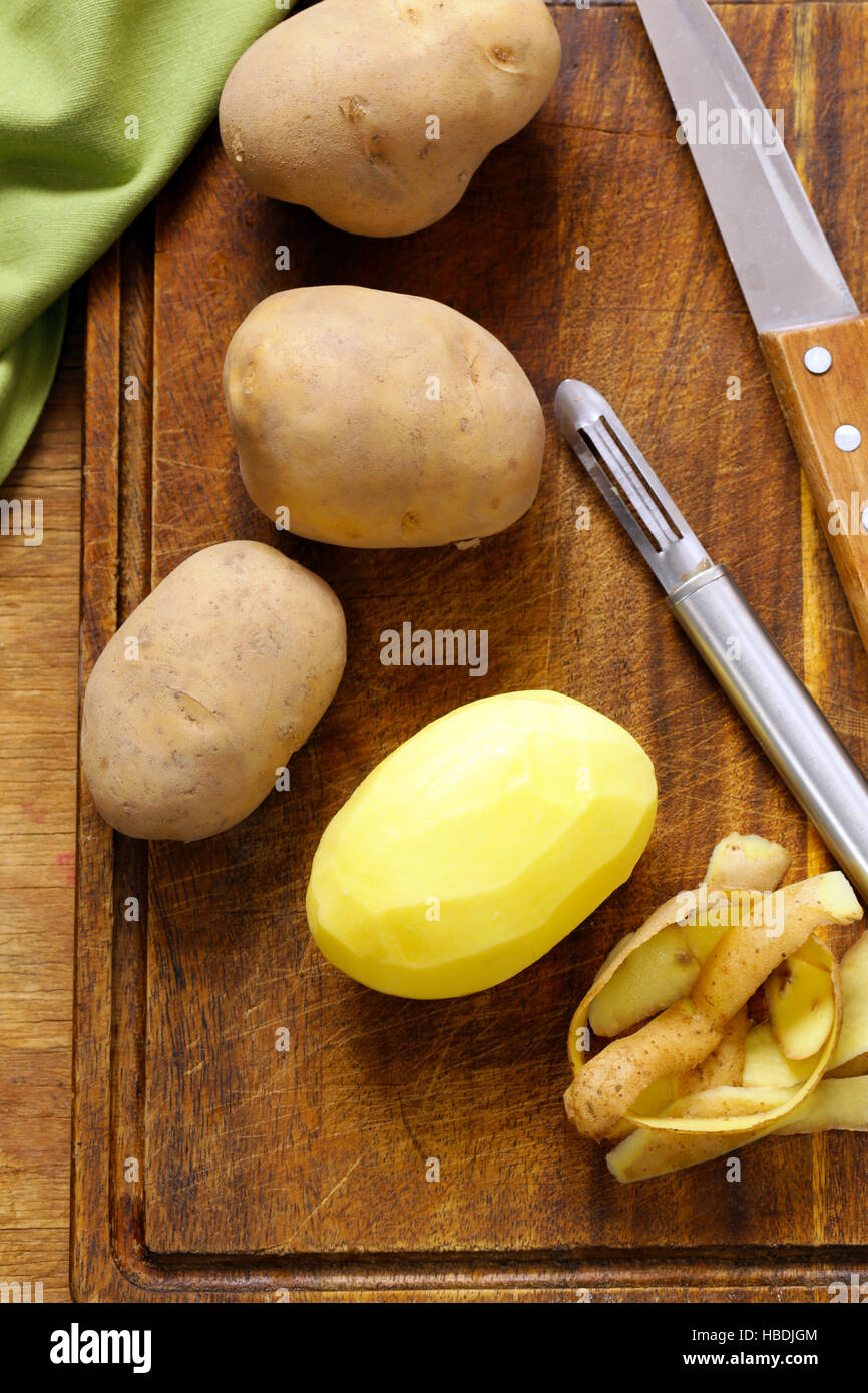 Peeled and sliced raw potatoes on a cutting board Stock Photo - Alamy