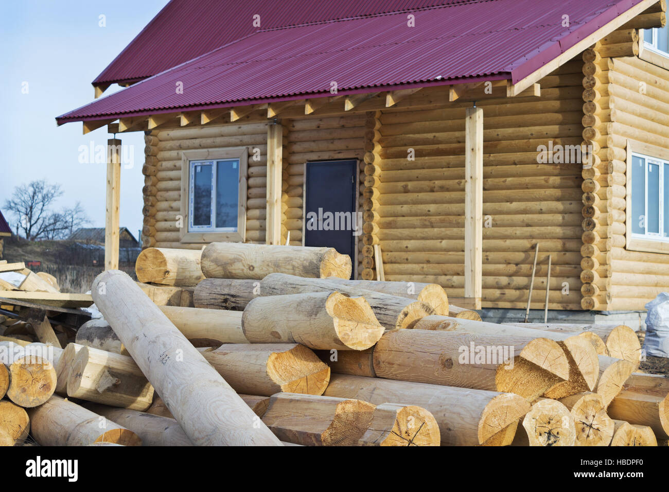 A pile of logs and wooden house Stock Photo - Alamy