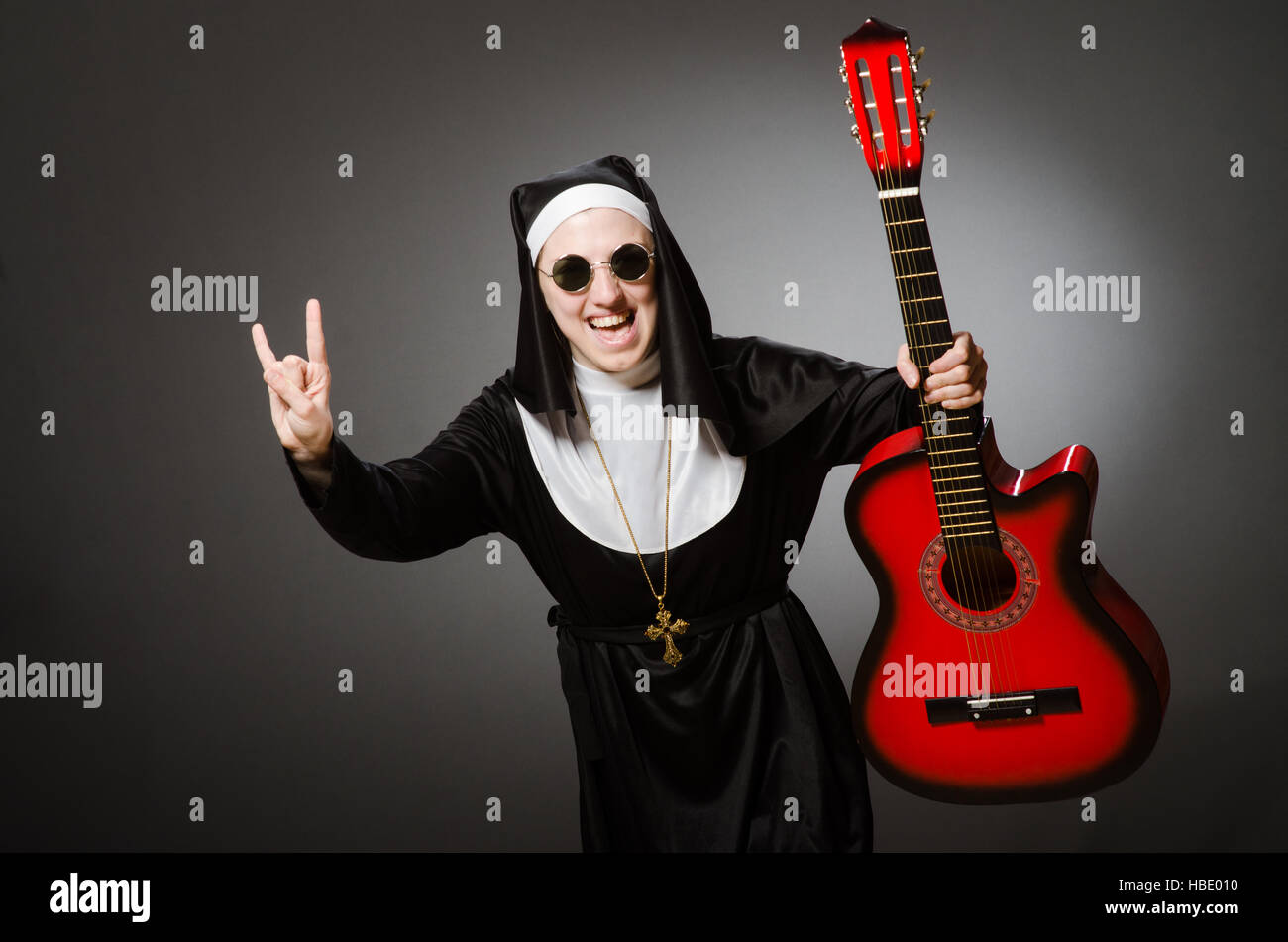 Funny nun with red guitar playing Stock Photo - Alamy