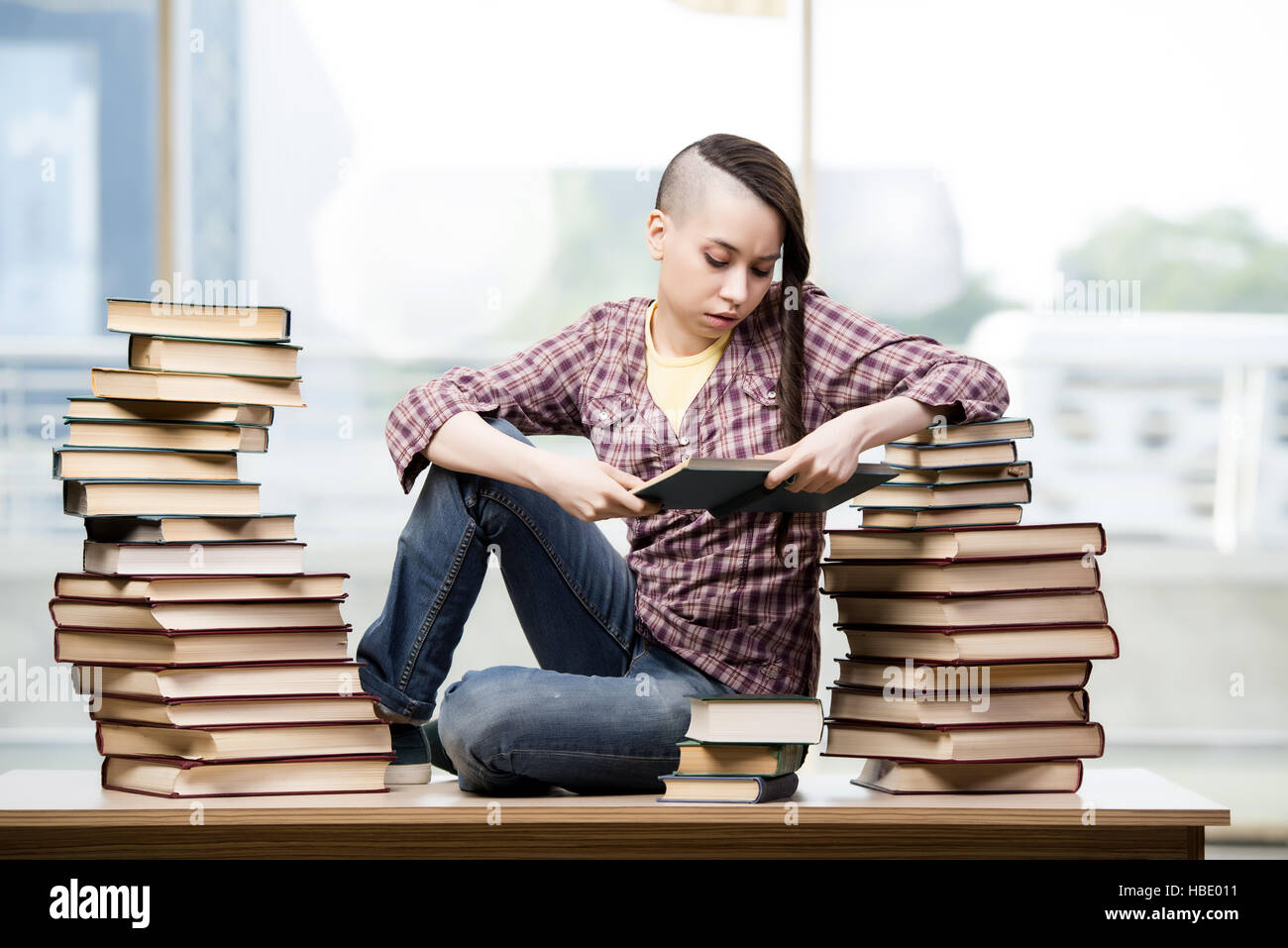 Young student with stack of books Stock Photo - Alamy