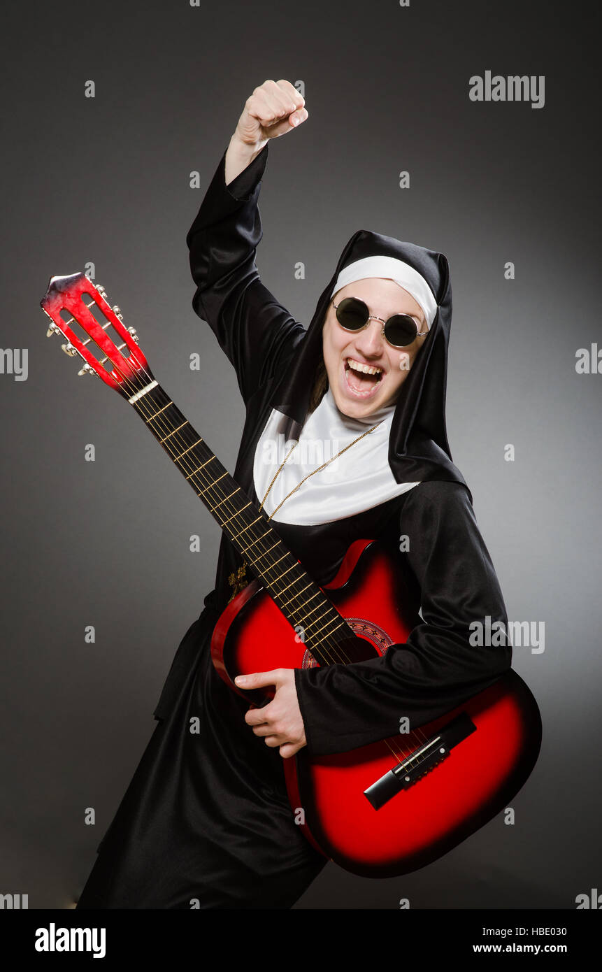 Funny nun with red guitar playing Stock Photo - Alamy