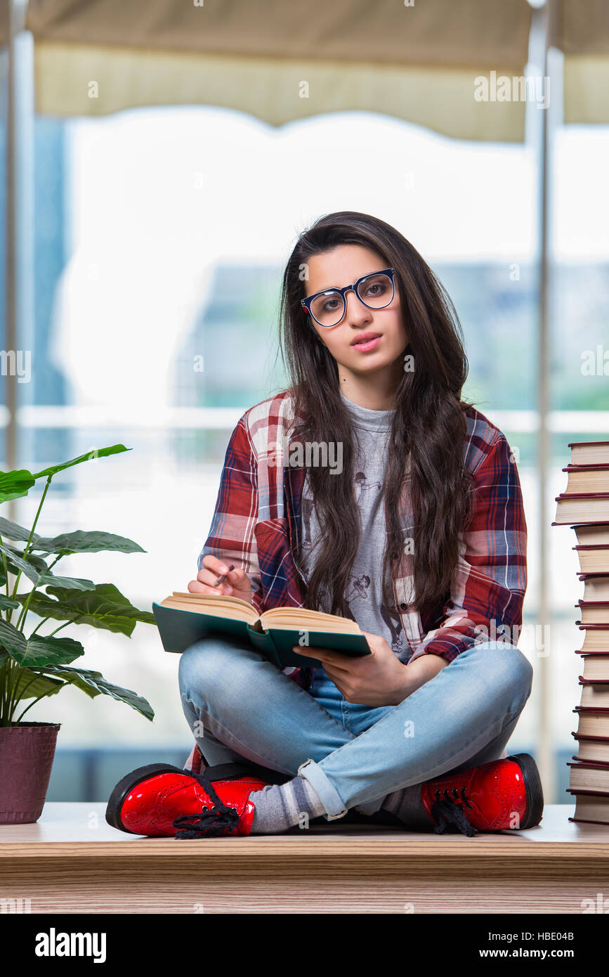 Student sitting on the desk with books Stock Photo - Alamy