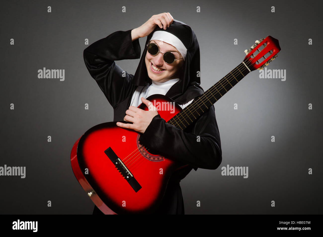 Funny nun with red guitar playing Stock Photo - Alamy