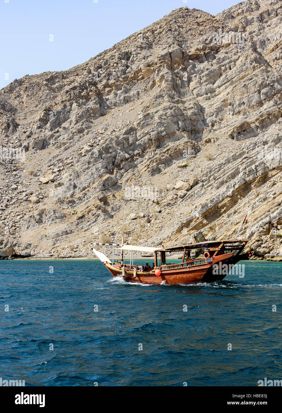 Vertical view of a traditional dhow sailing through the scenic Khasab ...