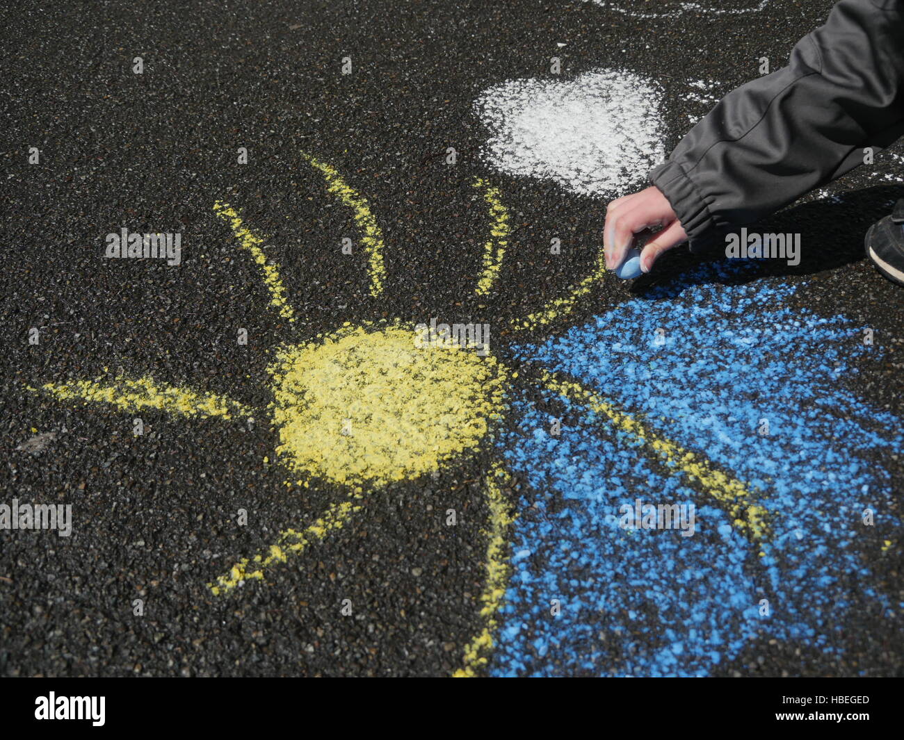 Unrecognizable kid drawing with chalk on asphalt Stock Photo - Alamy