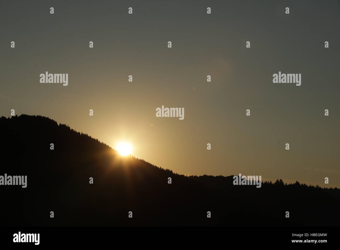 sun setting behind the trees Stock Photo - Alamy