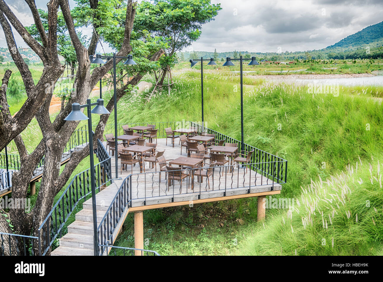 The wood table on natural outdoor of a restaurant with tree and cloudy ...