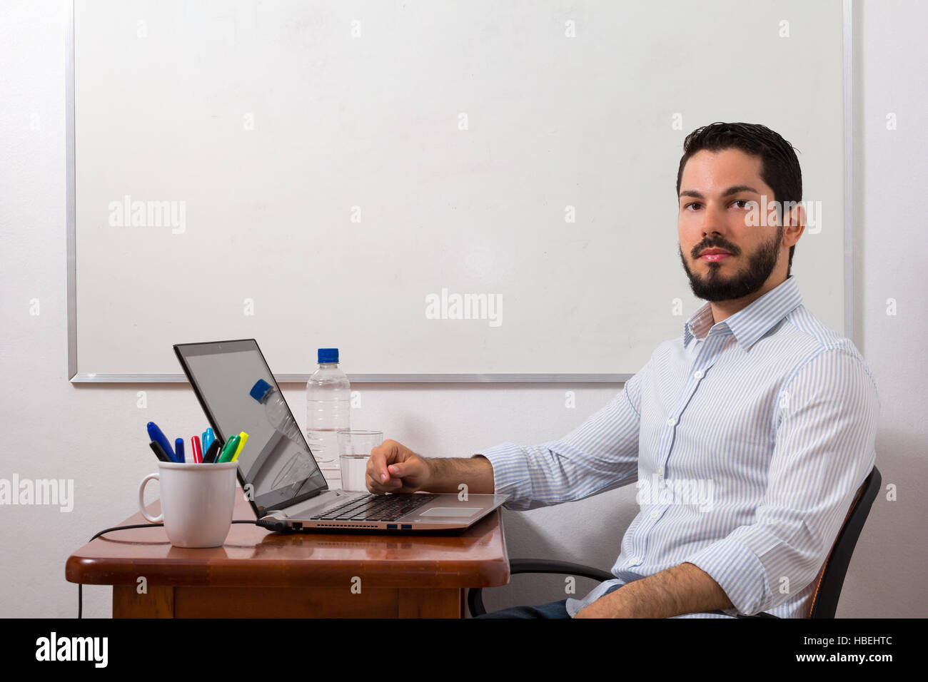 Young man at his desk posing for the photo Stock Photo - Alamy