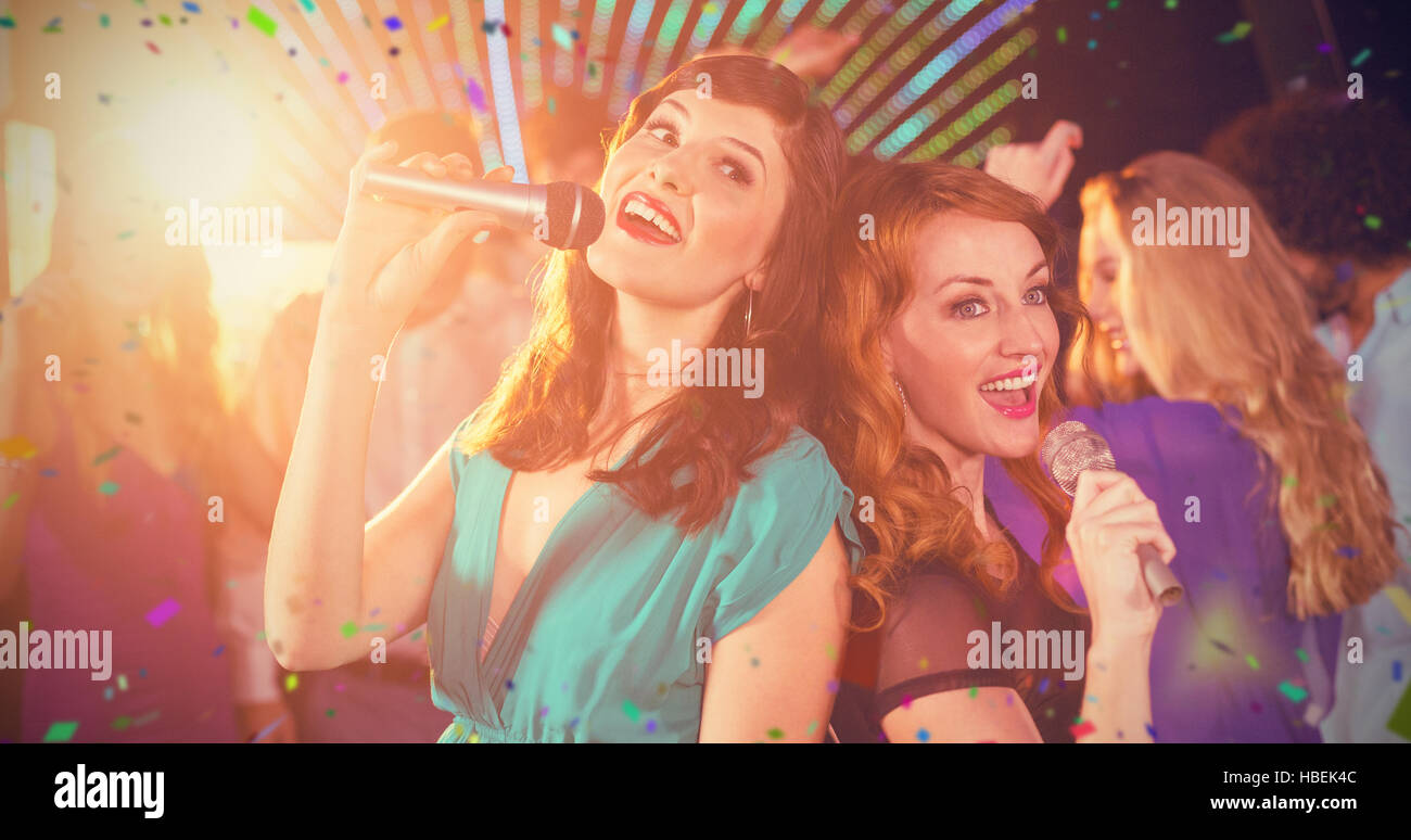 Composite image of two beautiful women singing song together Stock ...