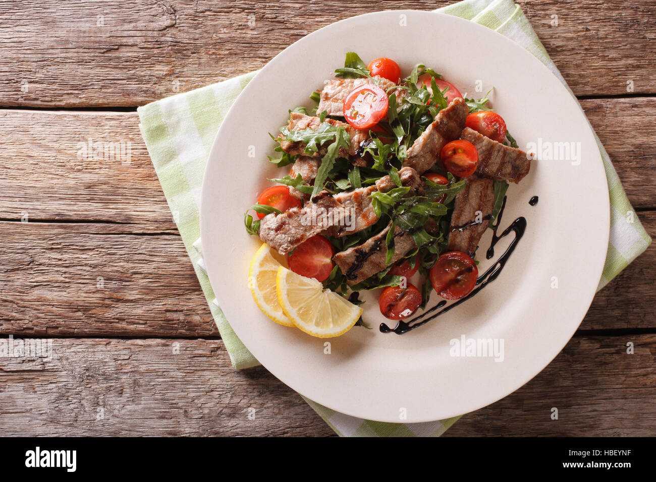 Straccetti Grilled beef with arugula and tomatoes close-up on the table ...