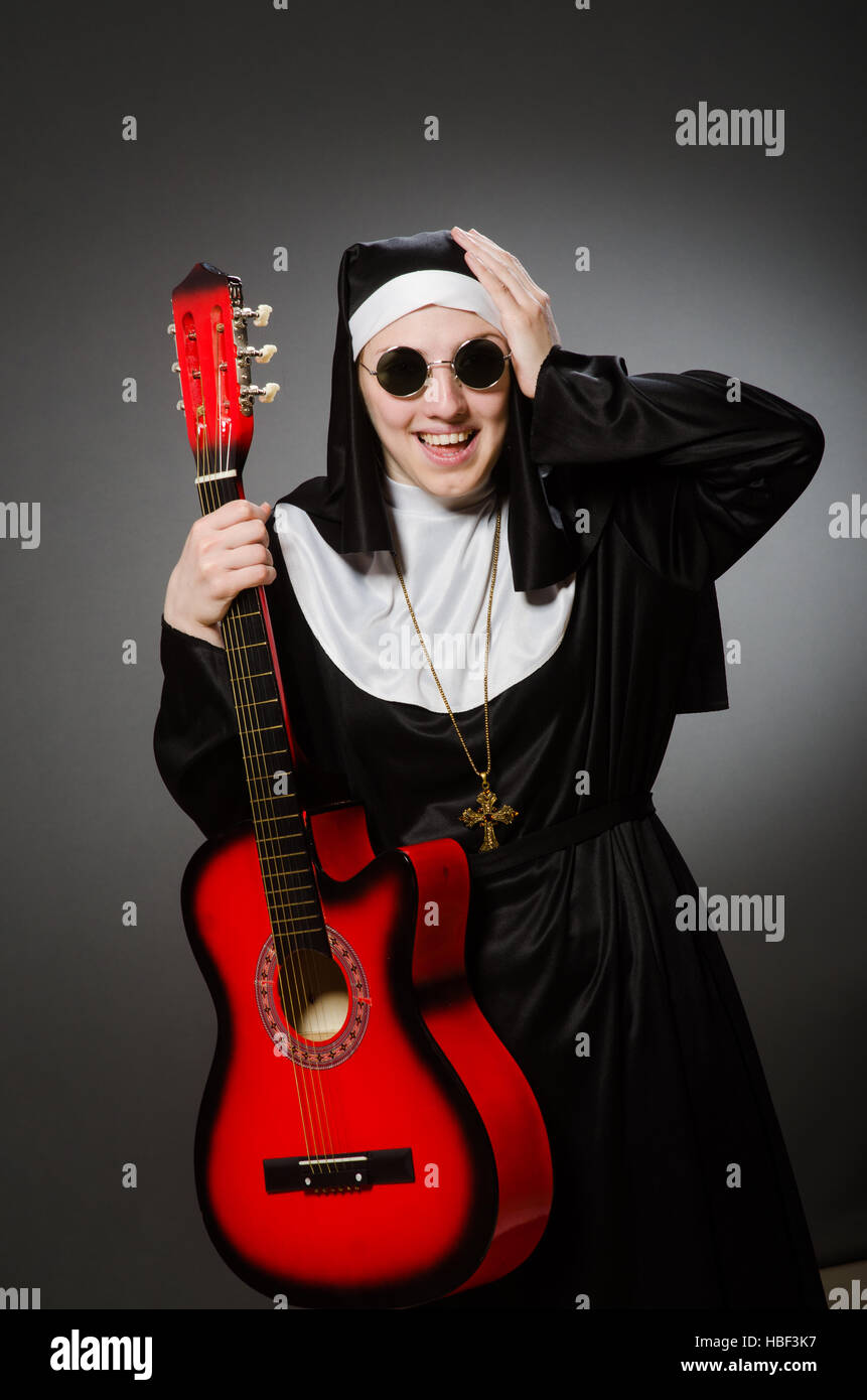 Funny nun with red guitar playing Stock Photo - Alamy