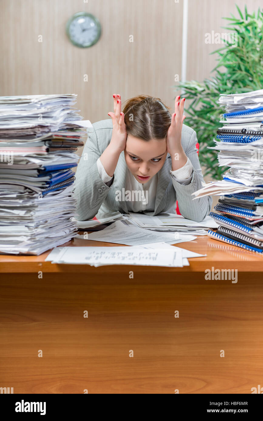 Woman under stress from excessive paper work Stock Photo - Alamy