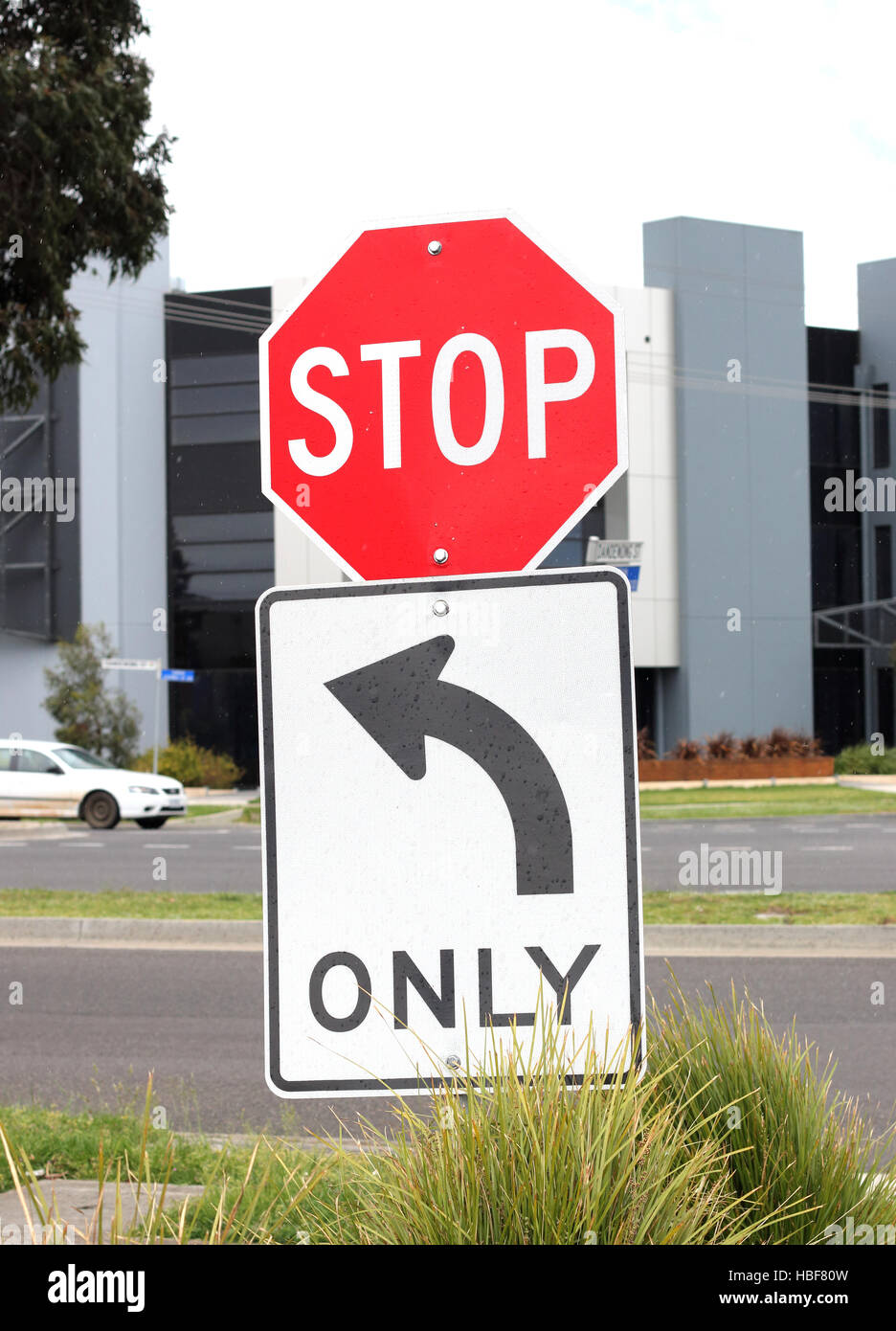 Stop sign with turn left arrow only Stock Photo - Alamy