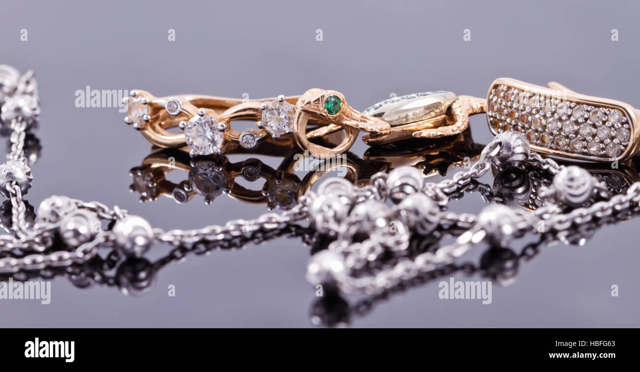 Gold earrings and elegant silver chain Stock Photo - Alamy