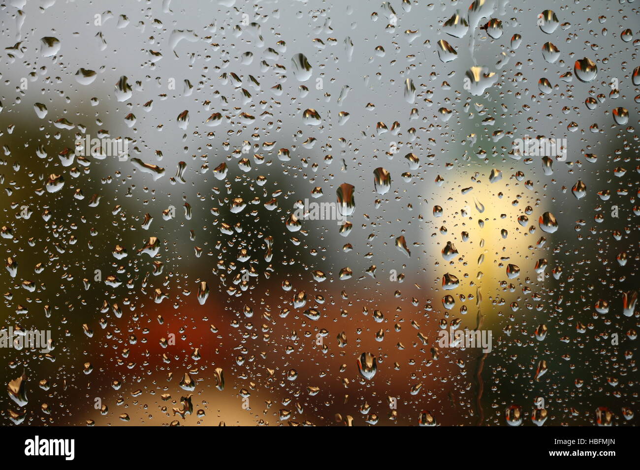Rain drops on window with house and church in background Stock Photo ...