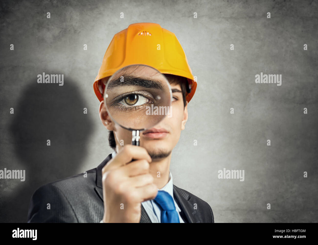 Construction man with magnifier Stock Photo - Alamy