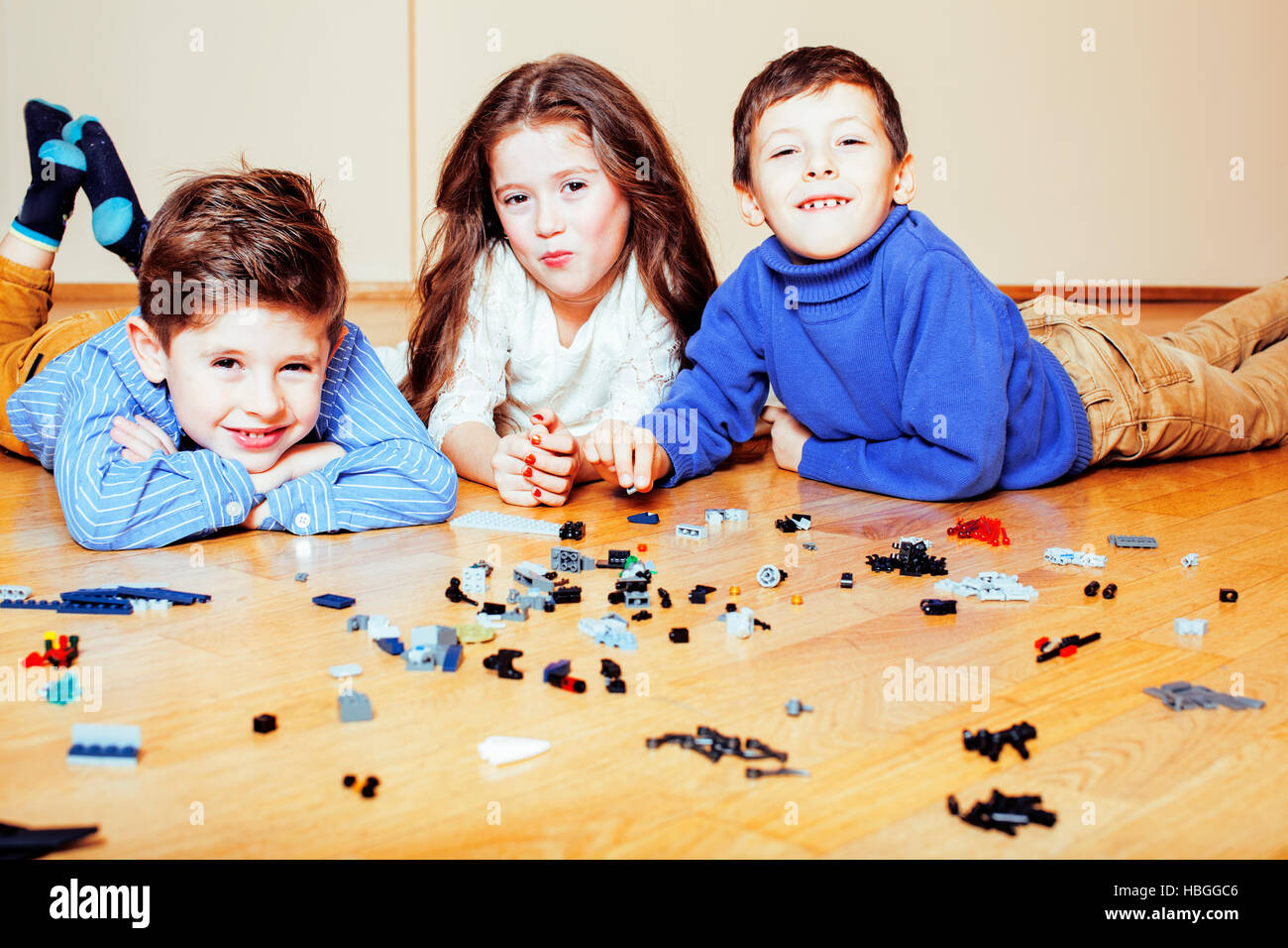 funny cute children playing lego at home, boys and girl smiling, first ...