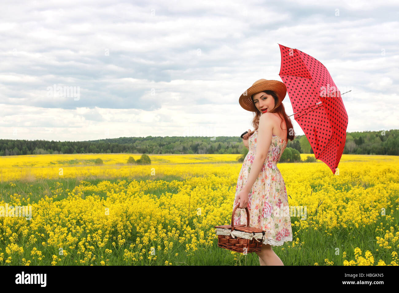 girl in a field of flowers with an umbrella and a hat Stock Photo - Alamy