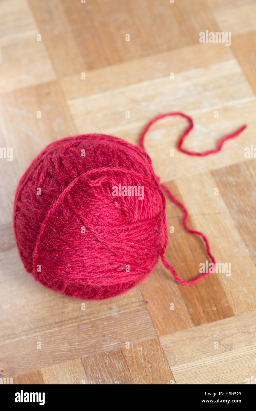 Red yarn ball on the woden floor Stock Photo - Alamy