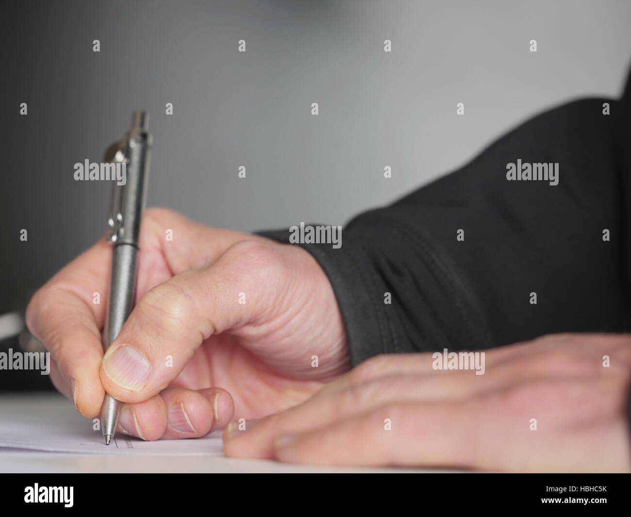 Close-up of man's hands writing with pen Stock Photo - Alamy