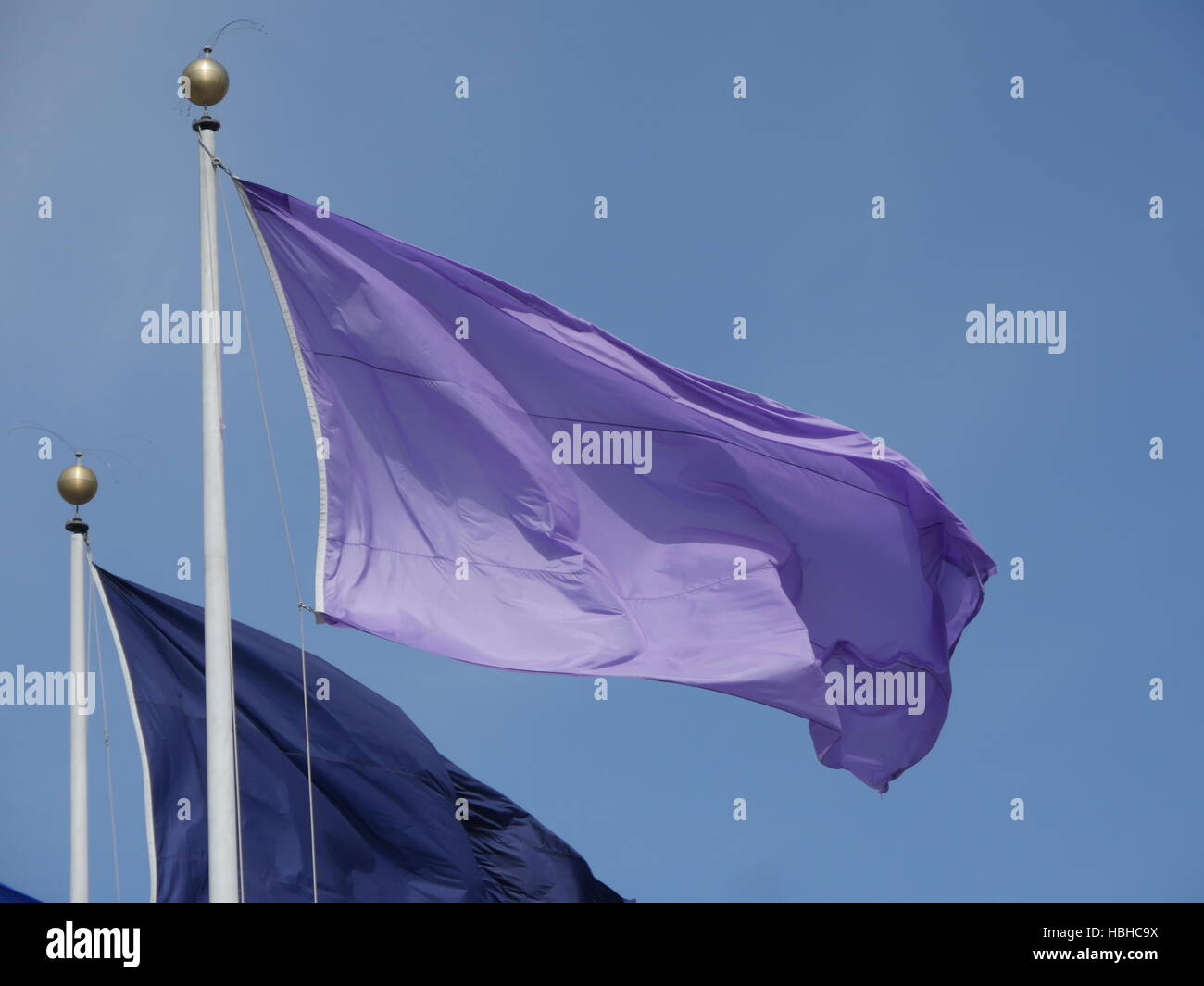 Flags of different colors on flagpoles Stock Photo - Alamy