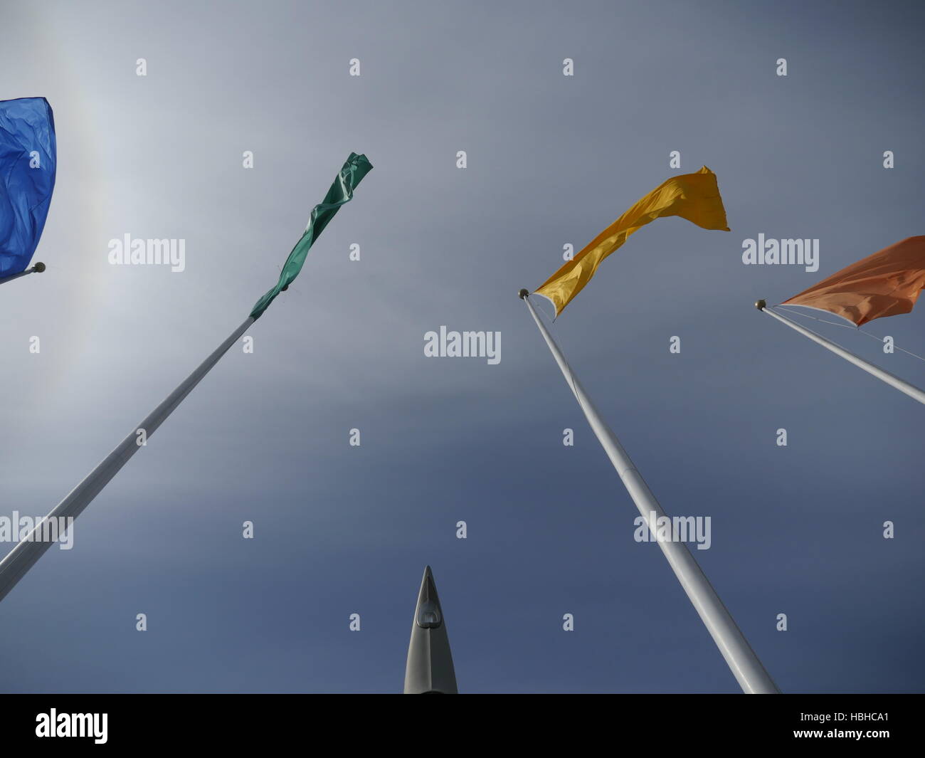 Flags of different colors on flagpoles Stock Photo - Alamy