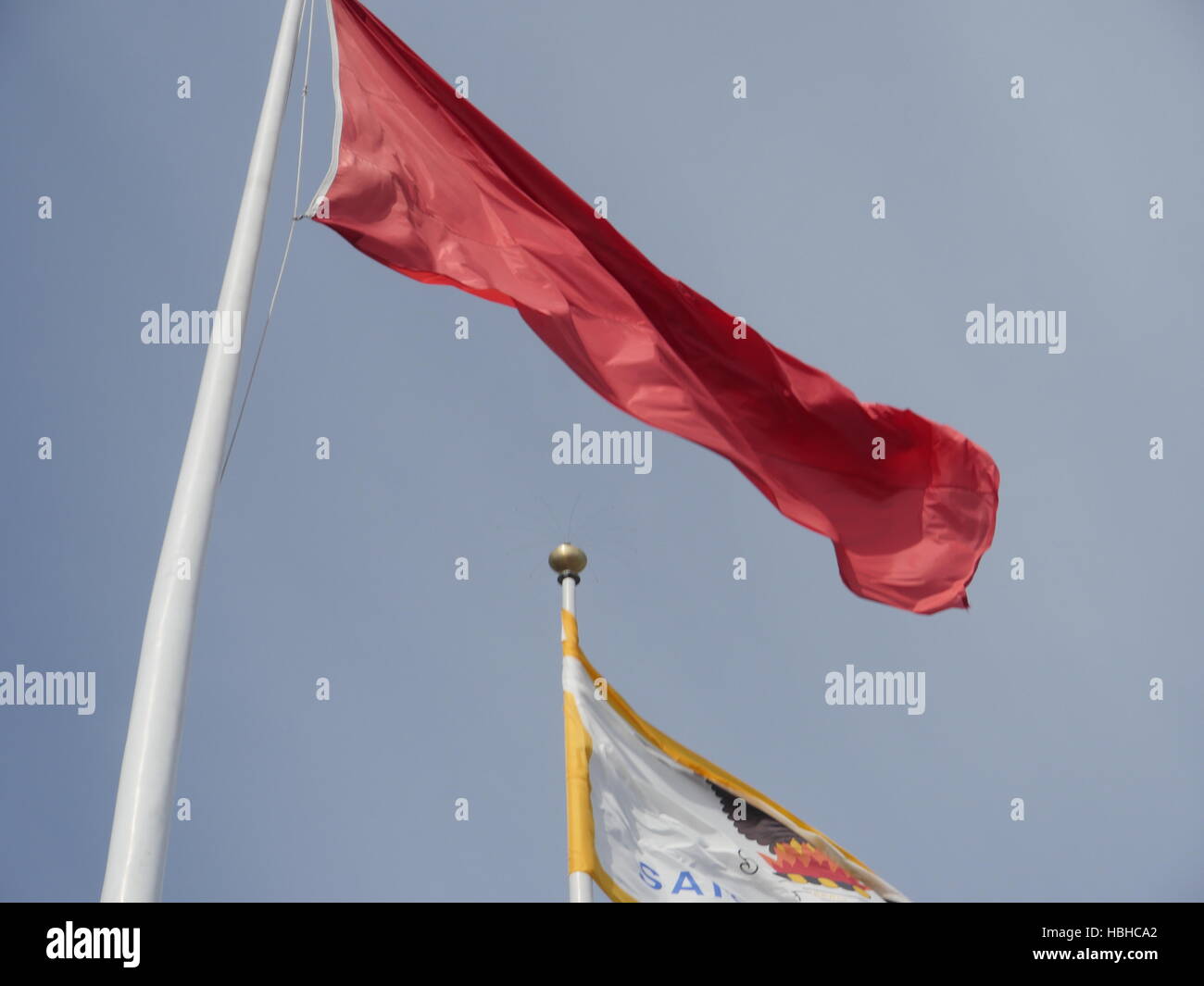 Flags of different colors on flagpoles Stock Photo - Alamy