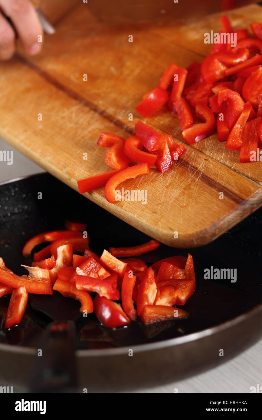 Adding sliced red bell pepper into frying pan. Making Chicken and Egg ...