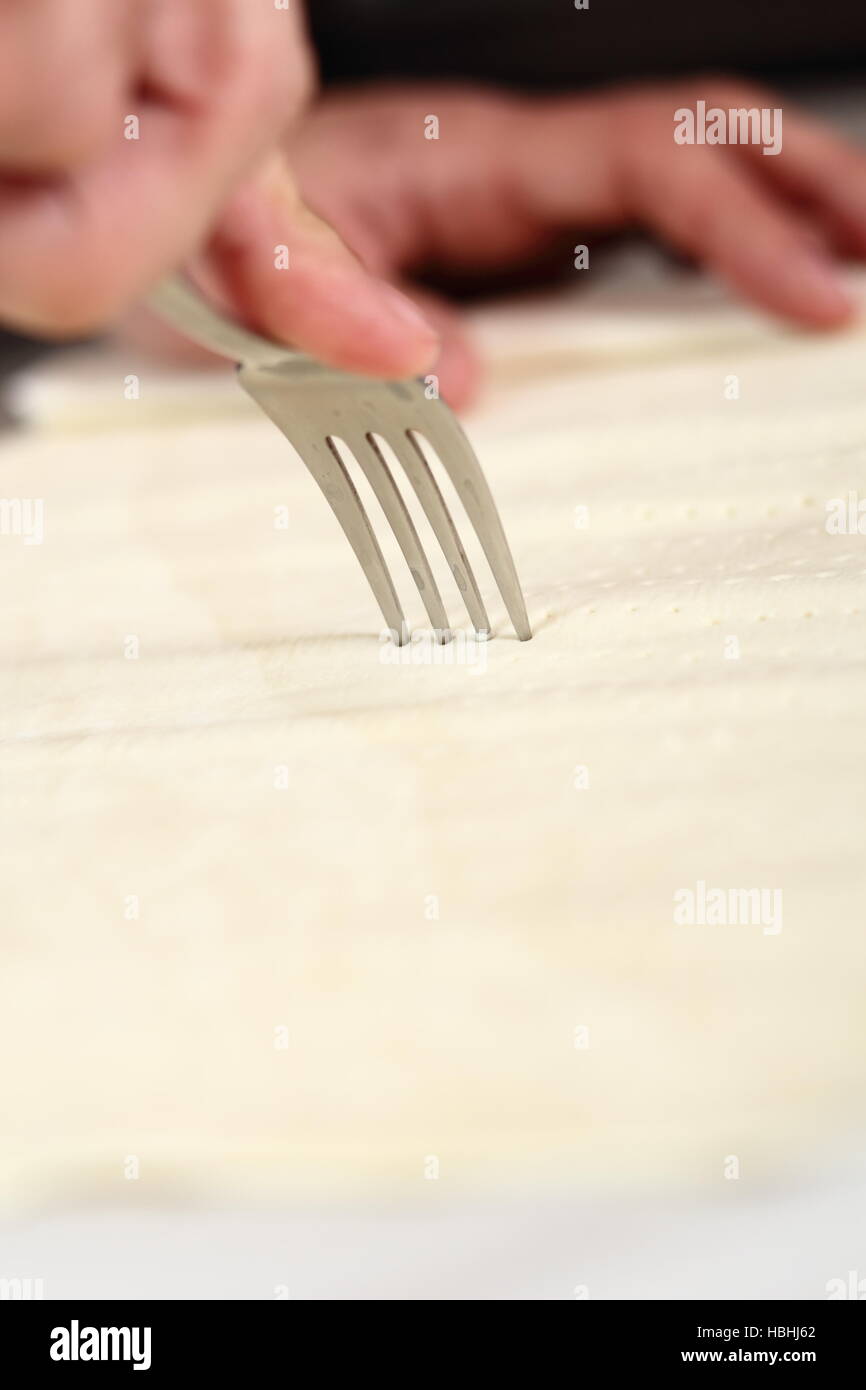 Pricking puff pastry sheet with fork. Making Pear Tarte Tatin with ...